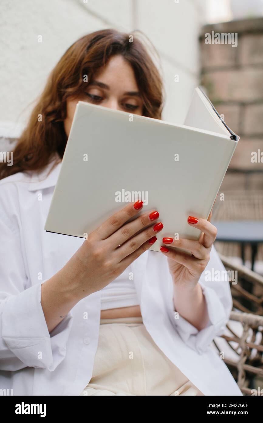 Mockup image magazine book. The girl at the coffee shop table reading ...