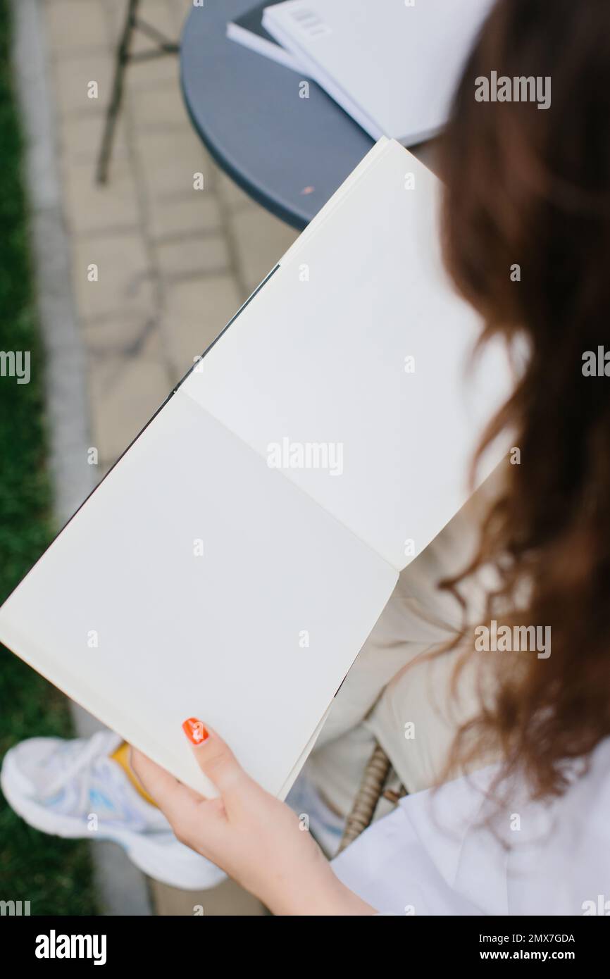 Mockup image magazine book. The girl at the coffee shop table reading ...