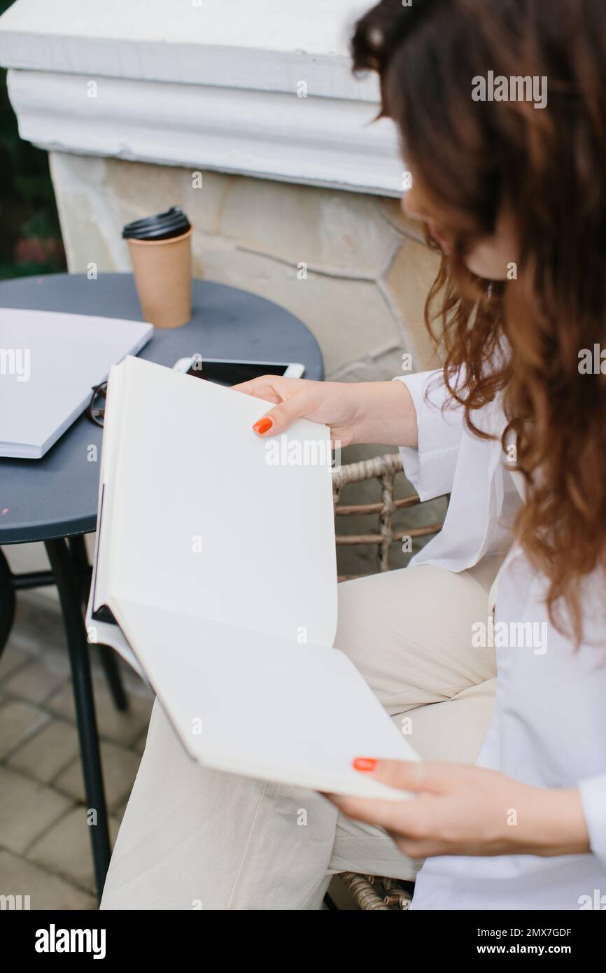 Mockup image magazine book. The girl at the coffee shop table reading ...