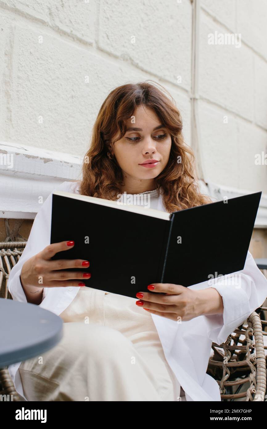 Mockup image magazine book. The girl at the coffee shop table reading ...