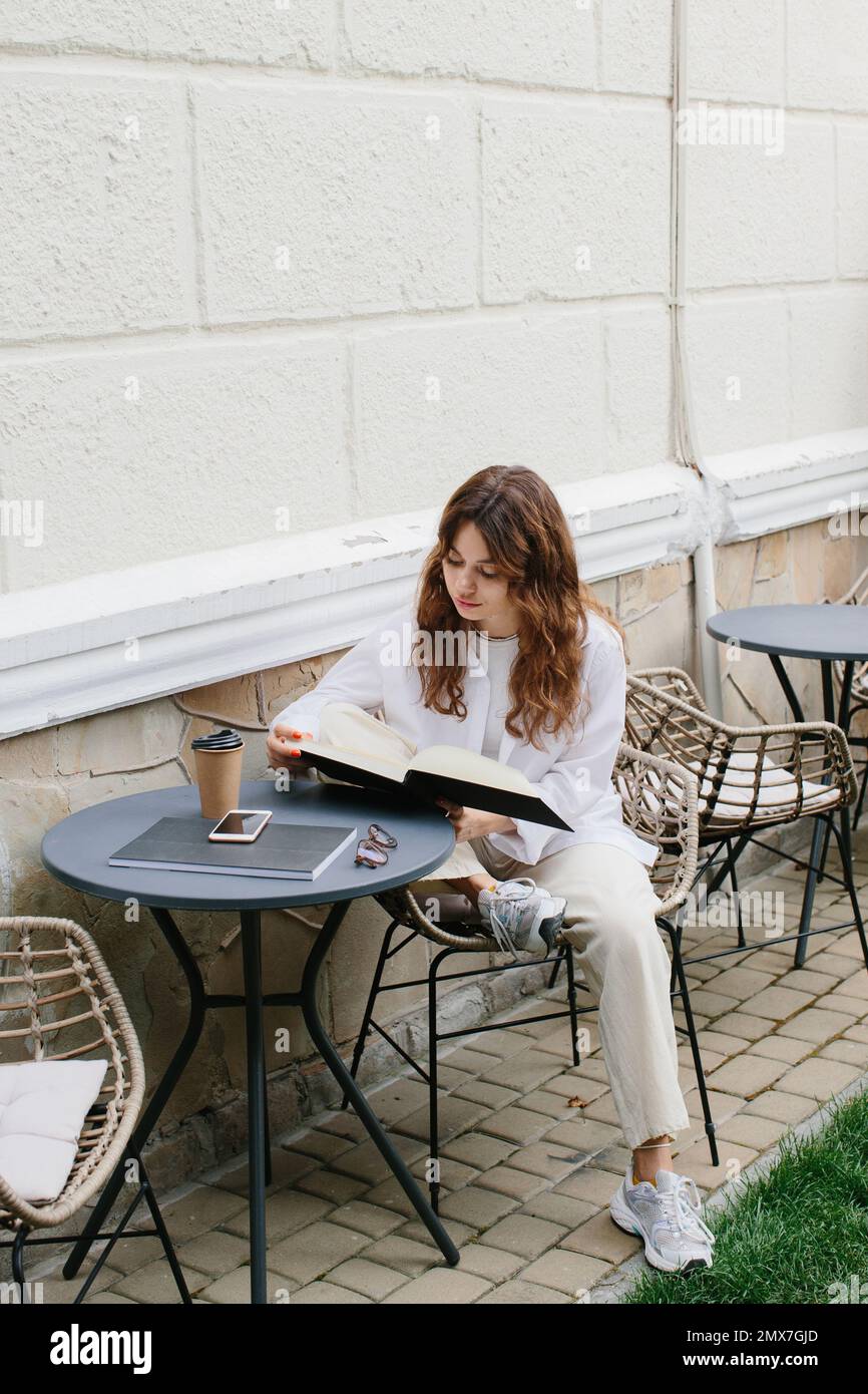 Mockup image magazine book. The girl at the coffee shop table reading ...