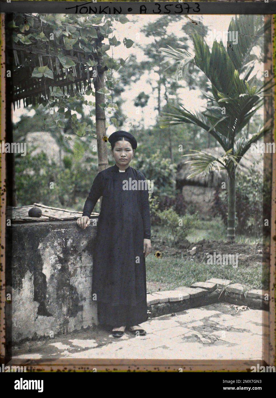Tonkin, Indochina, wealthy class girl, in front of a well, surmounted ...