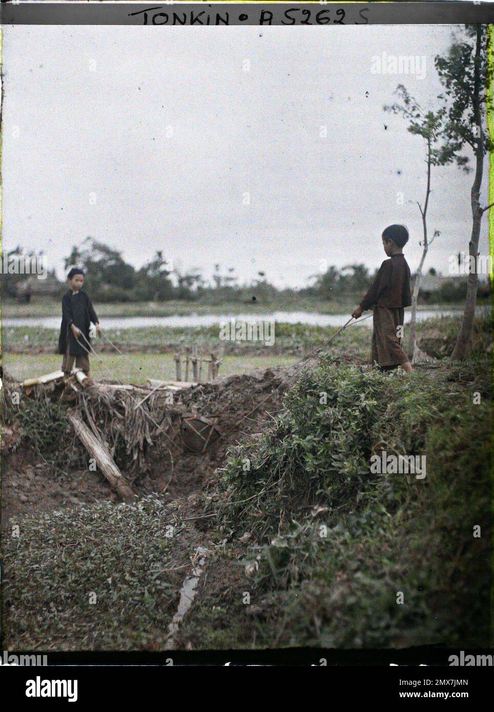 Tonkin, Indochina of children using a cord bucket, a lifting system of ...