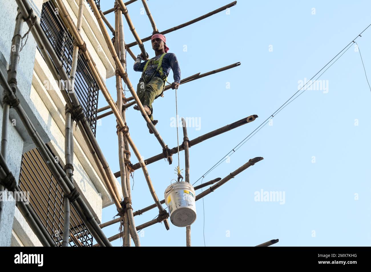 INDIA, Mumbai, apartment tower under renovation, bamboo scaffold ...