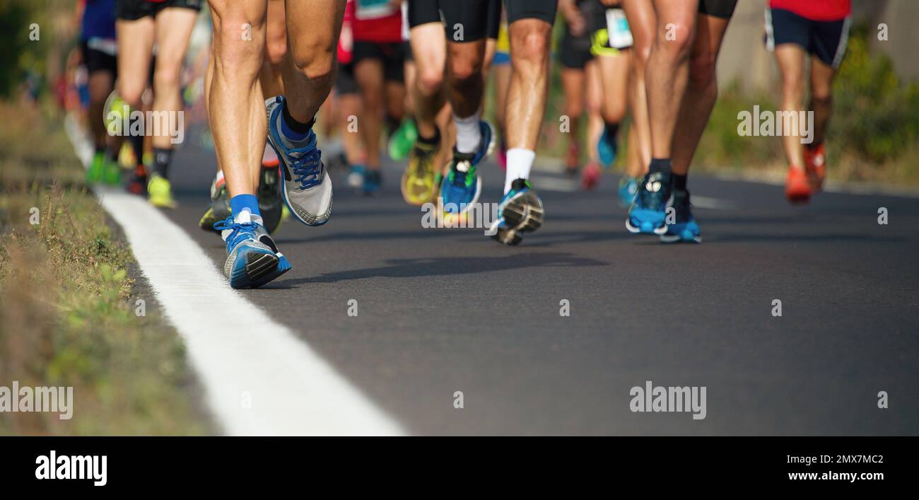 Marathon runners running on city road, large group of runners Stock ...