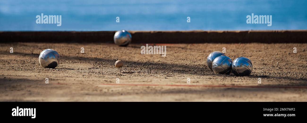 Metallic petanque four balls and a small wood jack Stock Photo - Alamy