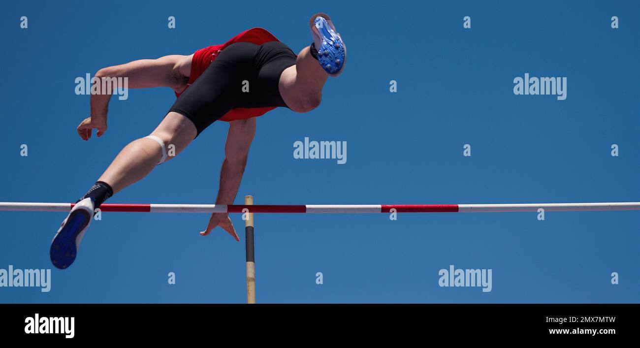 Competition pole vault jumper male on blue sky background Stock Photo ...