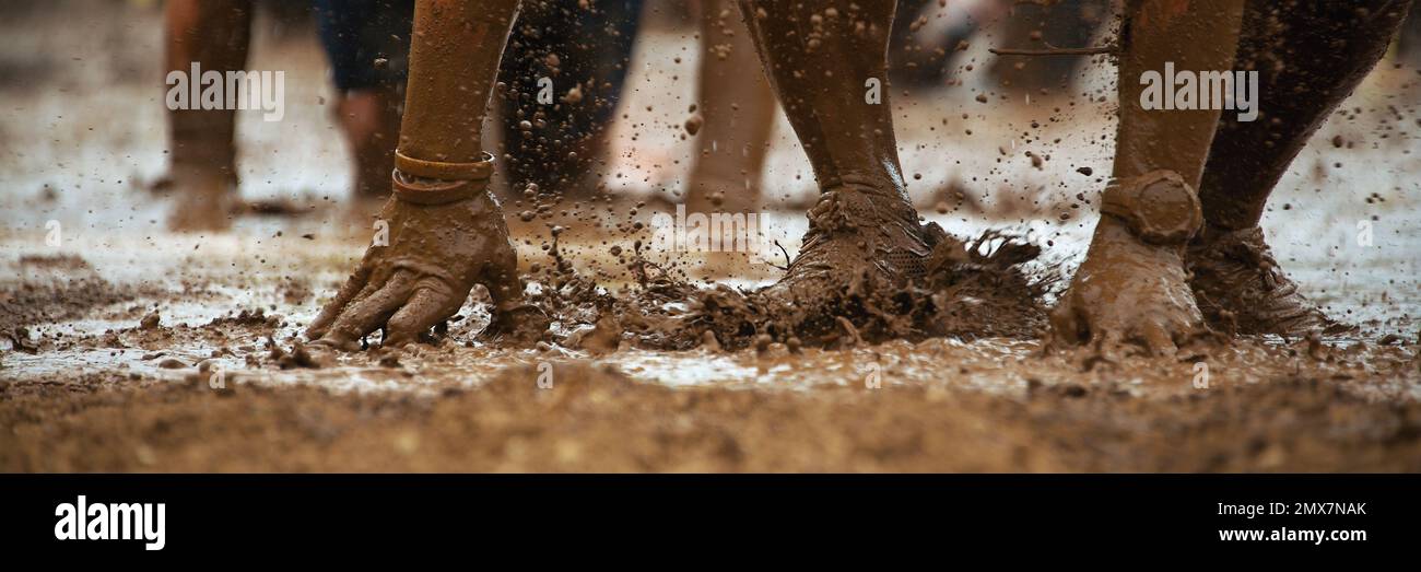 Mud race runners.Crawling,passing under a barbed wire obstacles during ...