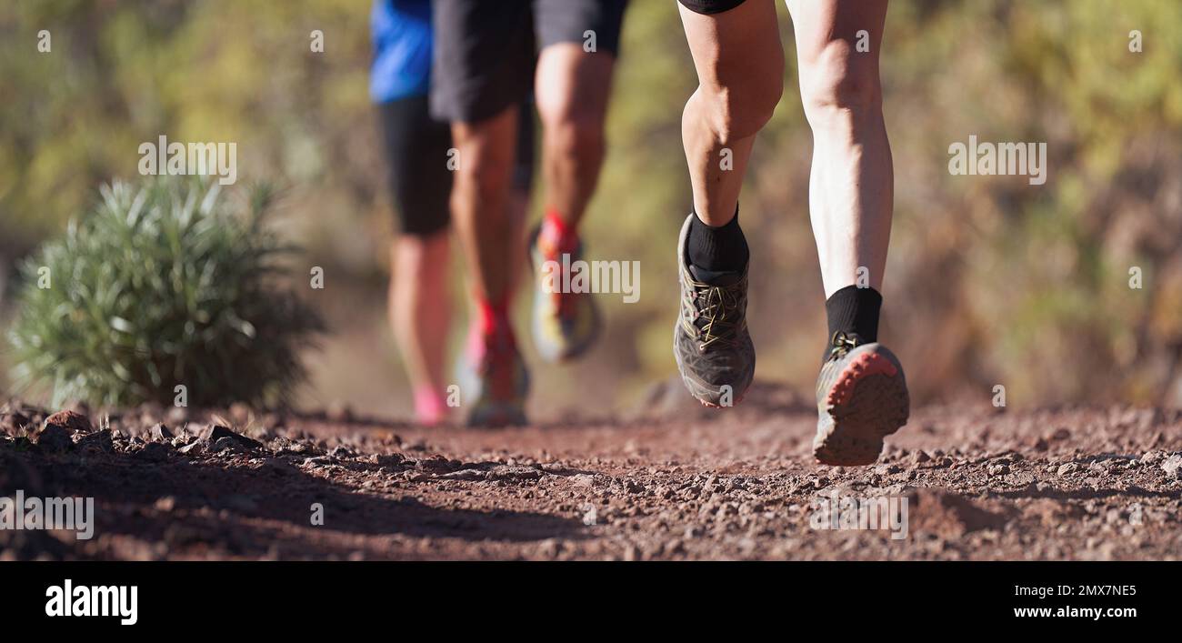 Runners running shoes on trail run. Ultra running athletes legs close ...