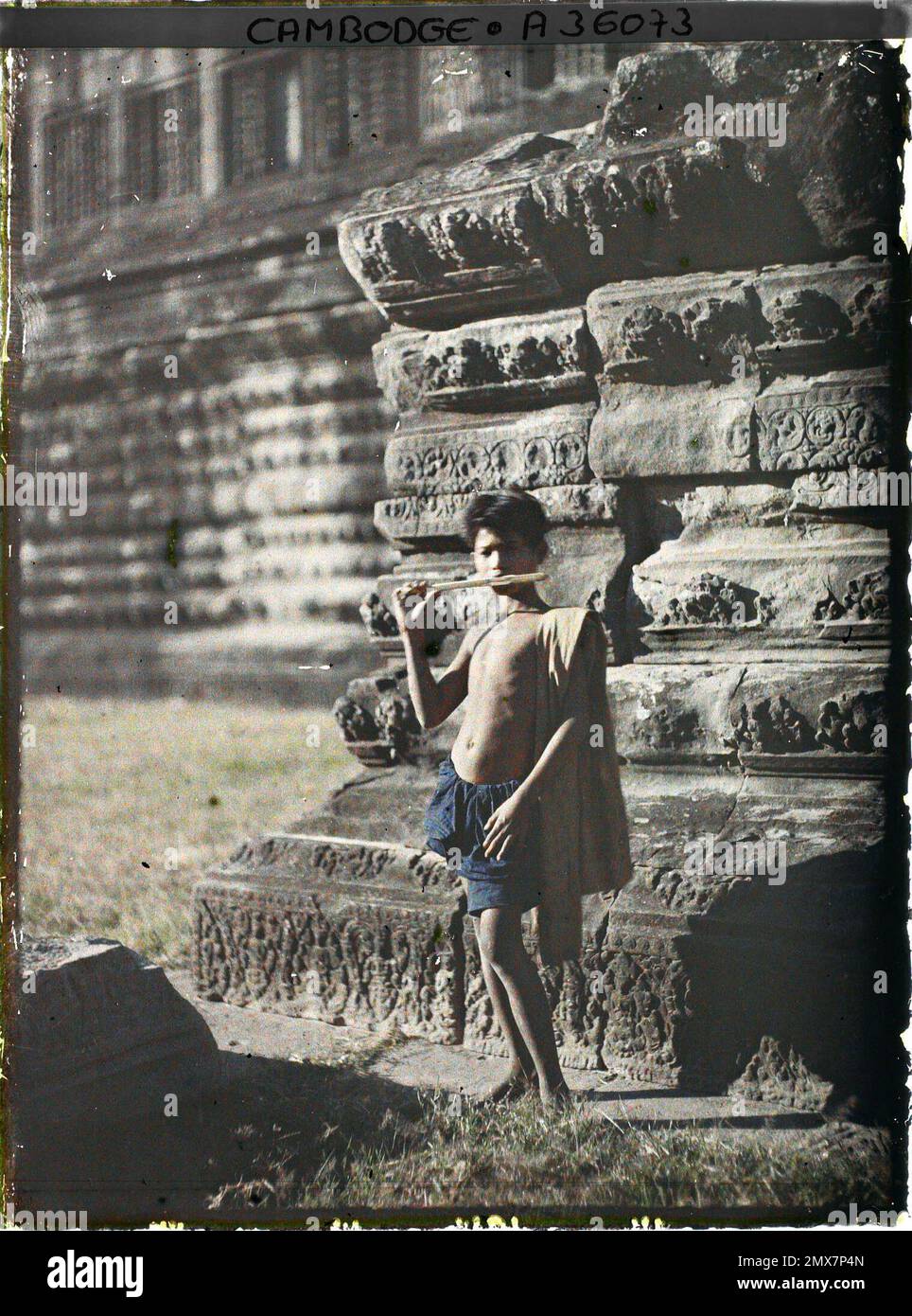 Angkor, Cambodia, Indochina a young flute player, at the foot of the ...