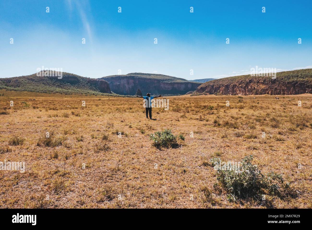 Rear view of a hiker against rock formations at Hell's Gate National ...