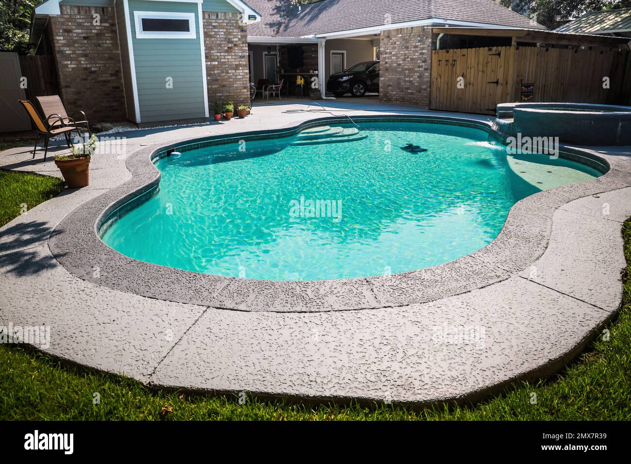 A large free form gray grey accent swimming pool with turquoise blue ...