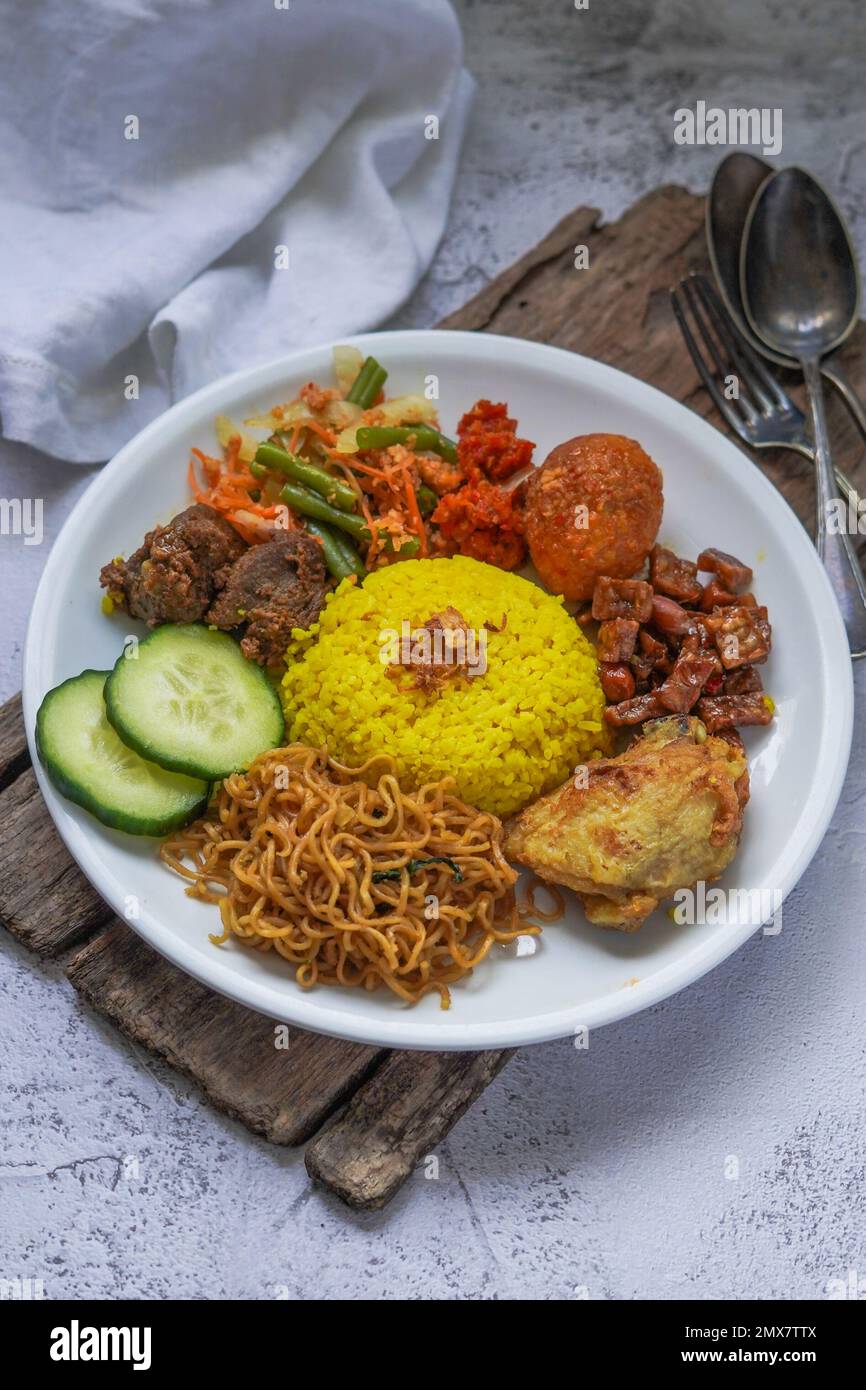 Indonesian traditional food, nasi kuning / yellow turmeric rice served ...