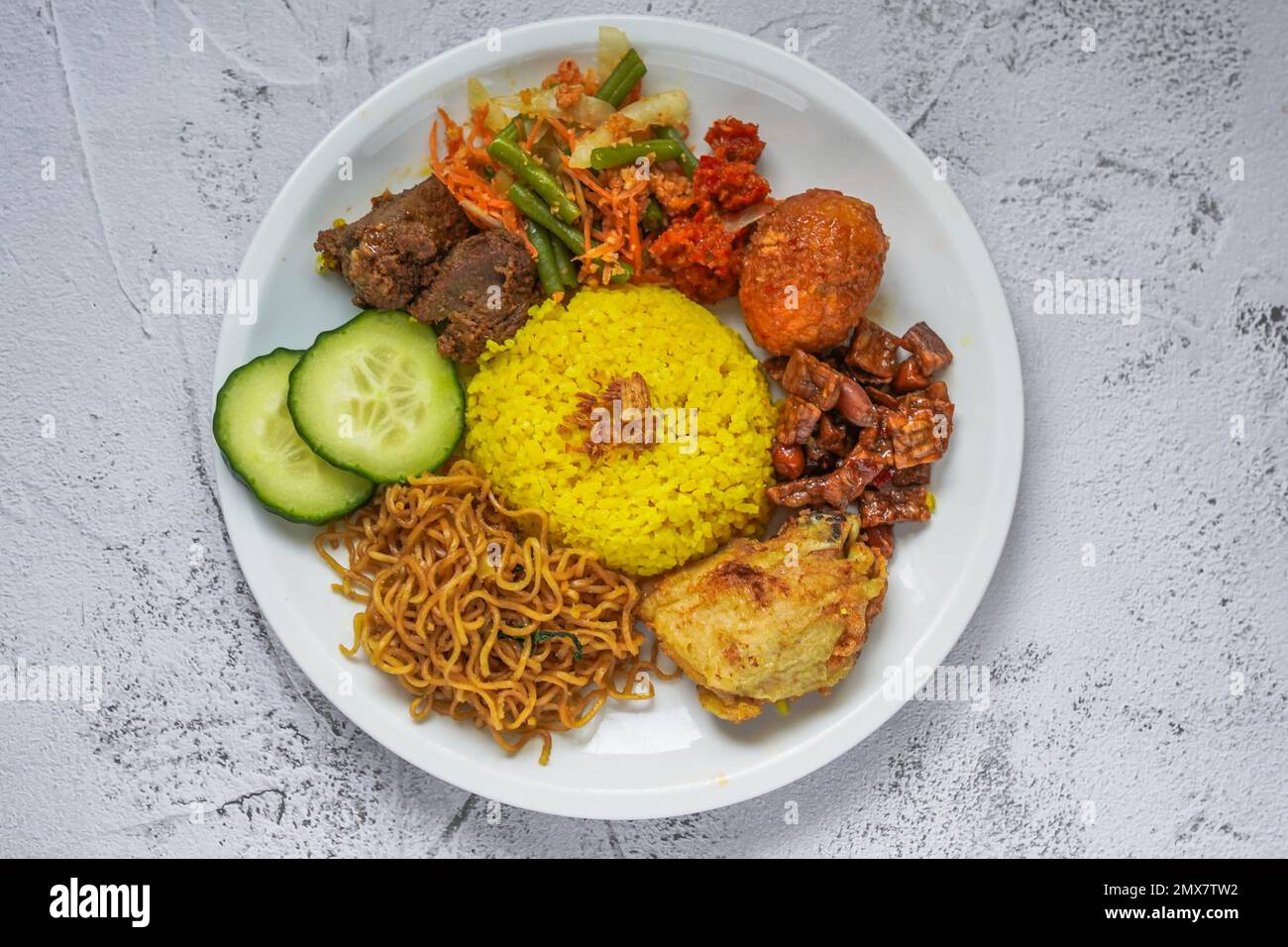 Indonesian traditional food, nasi kuning / yellow turmeric rice served ...