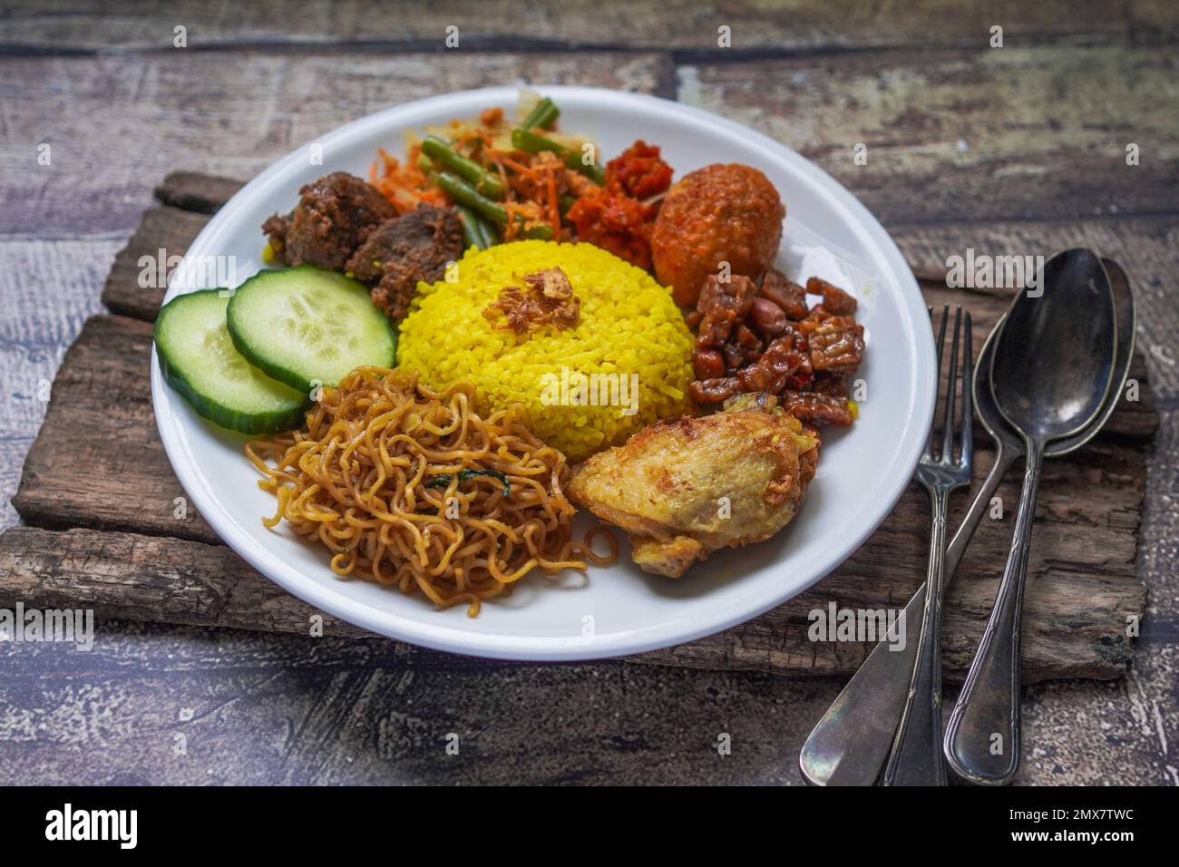 Indonesian traditional food, nasi kuning / yellow turmeric rice served ...