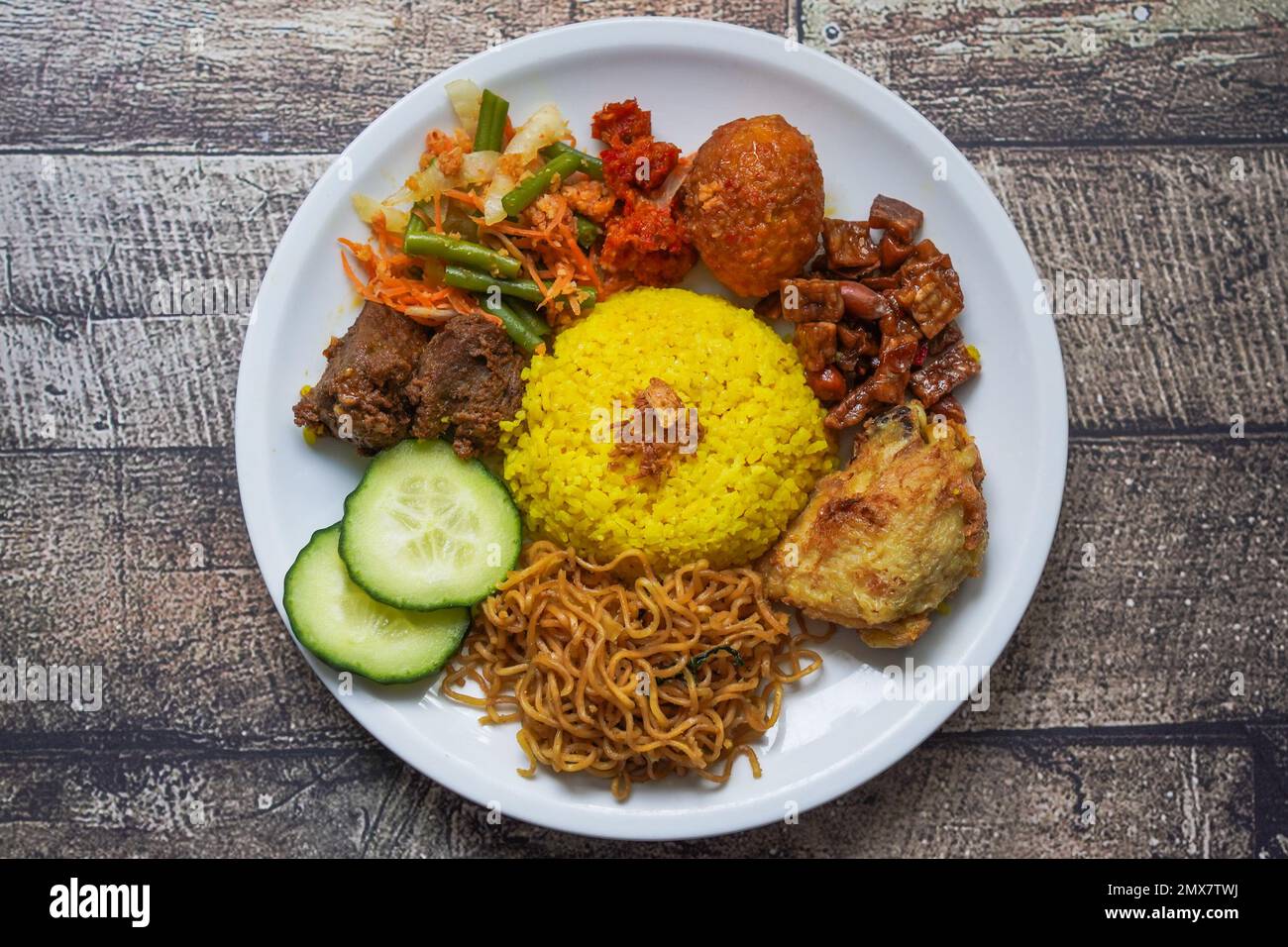 Indonesian traditional food, nasi kuning / yellow turmeric rice served ...