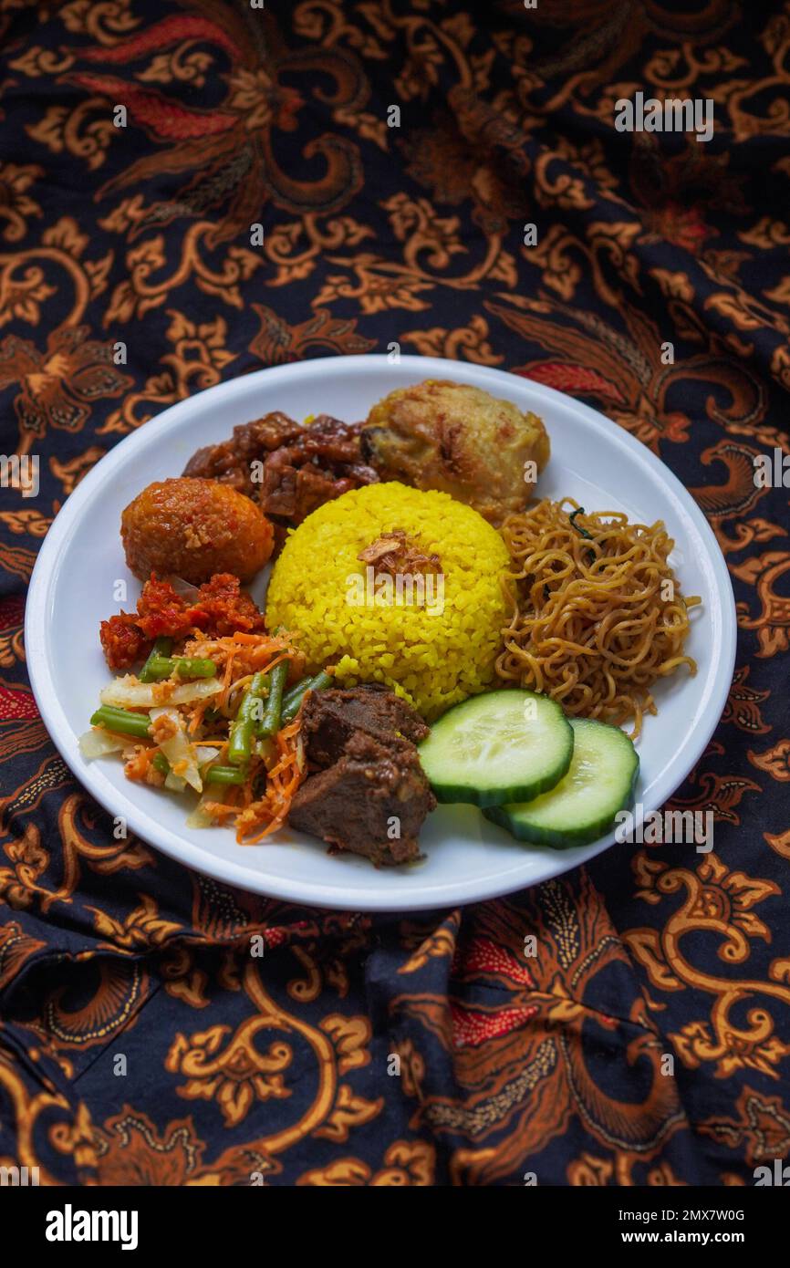 Indonesian traditional food, nasi kuning / yellow turmeric rice served ...