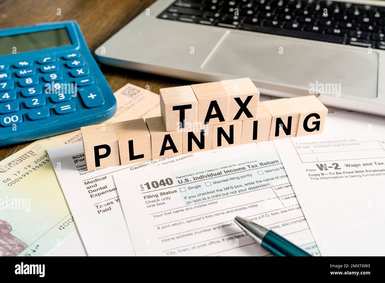 Tax Planning in wooden blocks with tax forms, computer and calculator ...