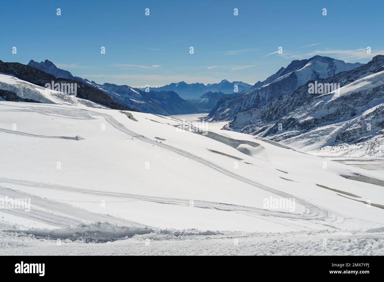 Snow plow tracks cross a frozen alpine landscape at Jungfraujoch ...