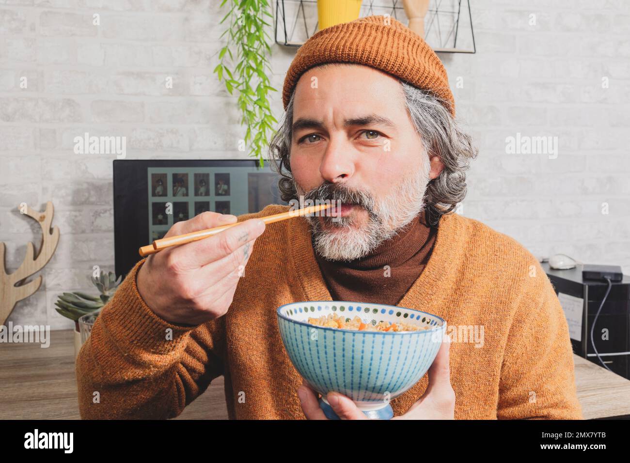 freelance man enjoying oriental food during lunch break at workplace ...
