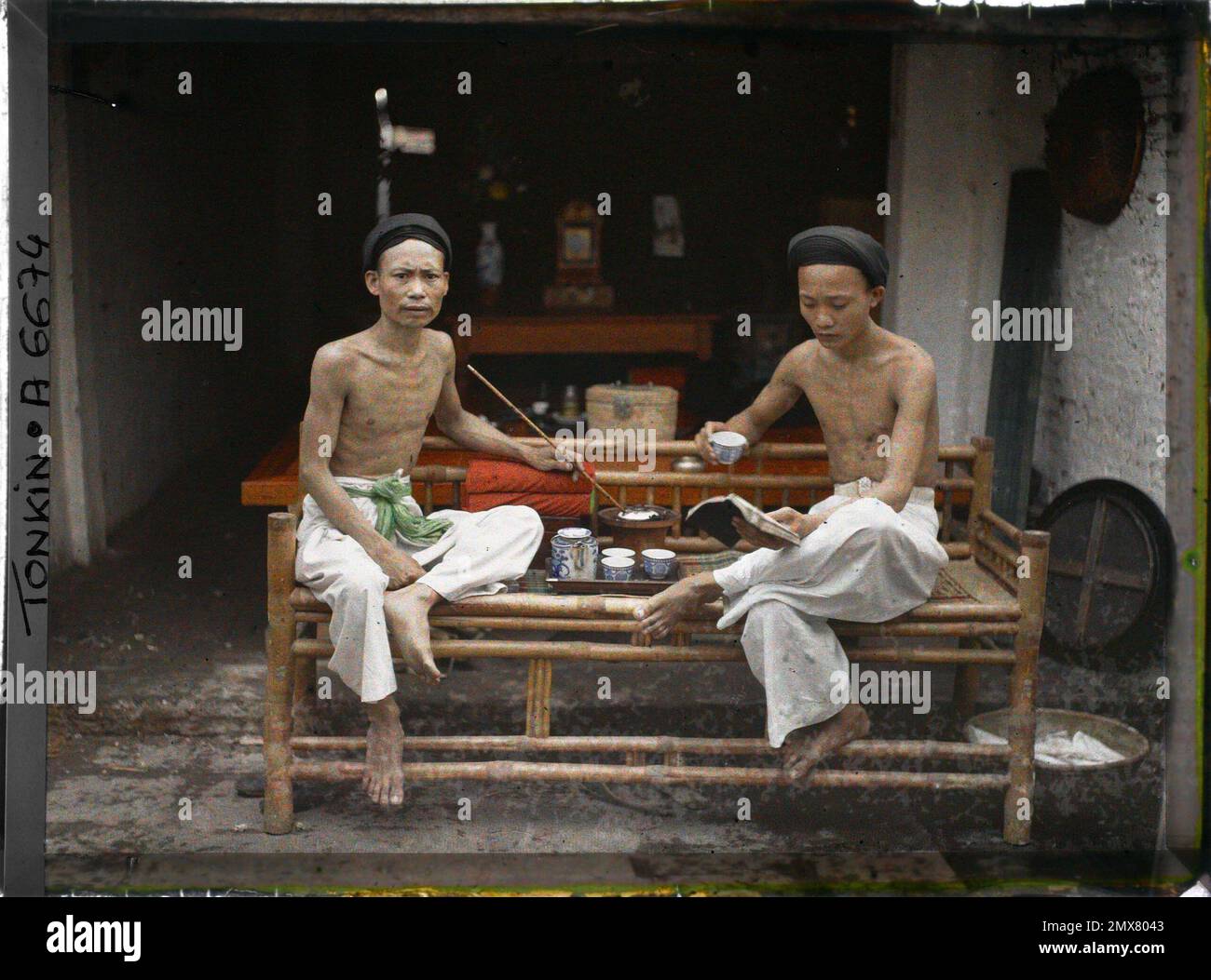 Hà-Nôi, Tonkin, Indochina Two men taking tea, smoking the water pipe ...