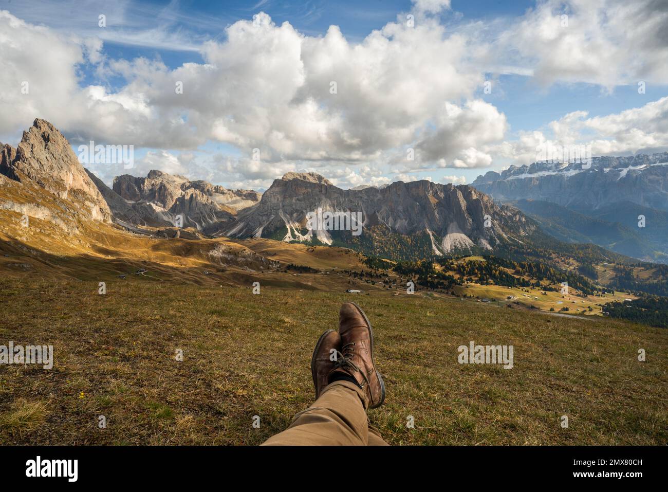 Legs of unrecognizable traveler in brown boots lying on green meadow ...