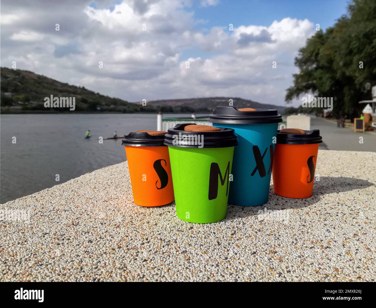 Four multi-colored disposable portable paper coffee cups of different ...