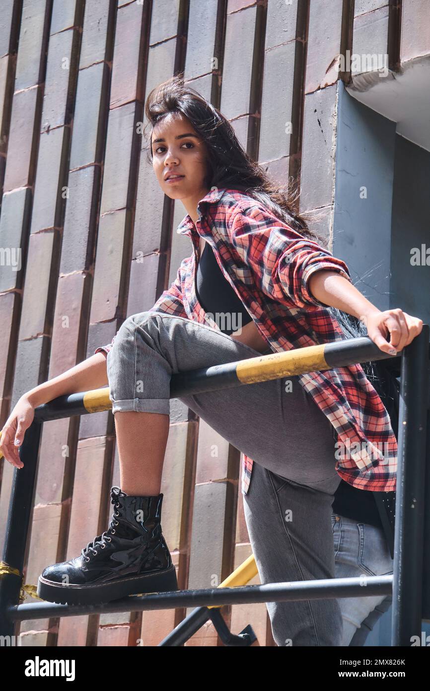 Side view of calm ethnic female model in colorful shirt and jeans with ...