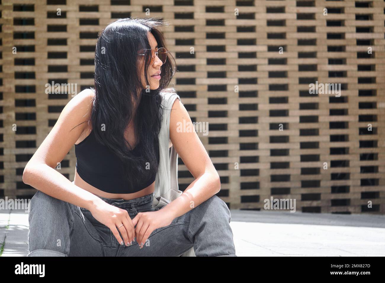 Full length of confident ethnic female model in sunglasses with long ...