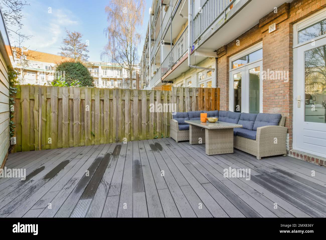 Exterior of spacious terrace with sofa and table placed near window of ...
