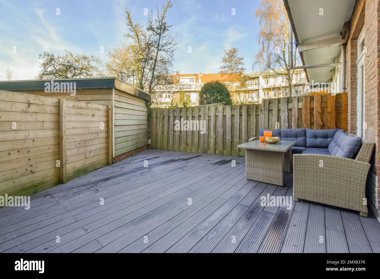 Exterior of spacious terrace with sofa and table placed near window of ...