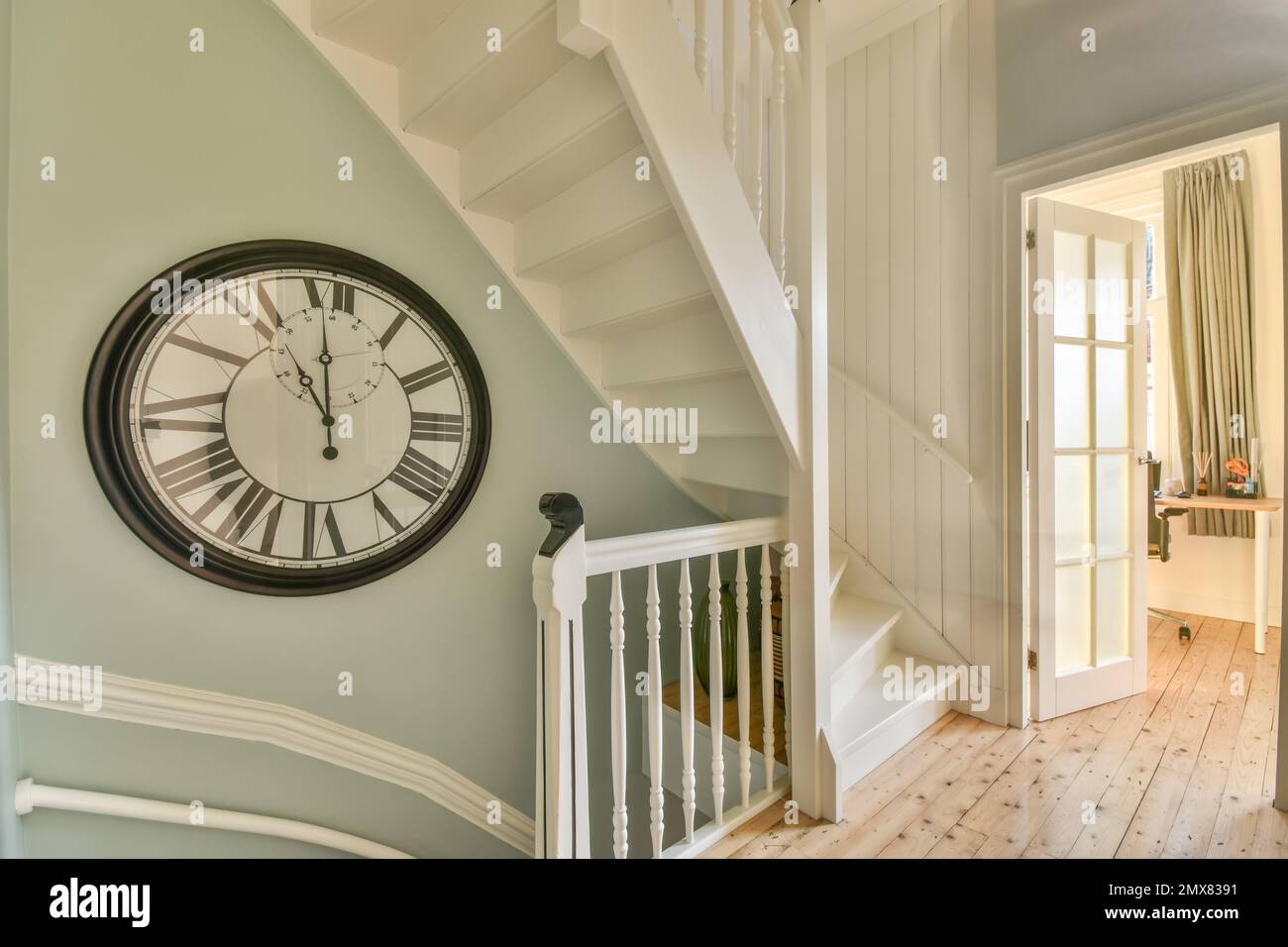 Interior of spacious light house with wooden staircase and clock ...