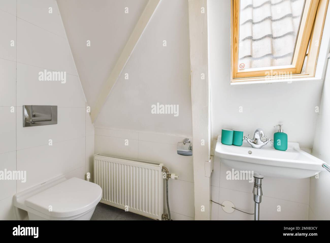 Interior of light bathroom with toilet bowl and sink placed under ...