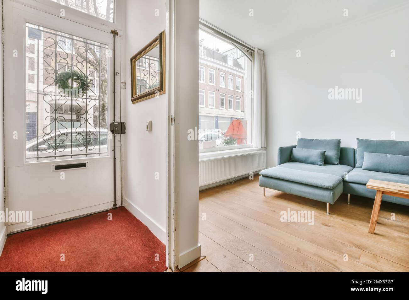 Comfortable couch placed on wooden floor in front of window against ...