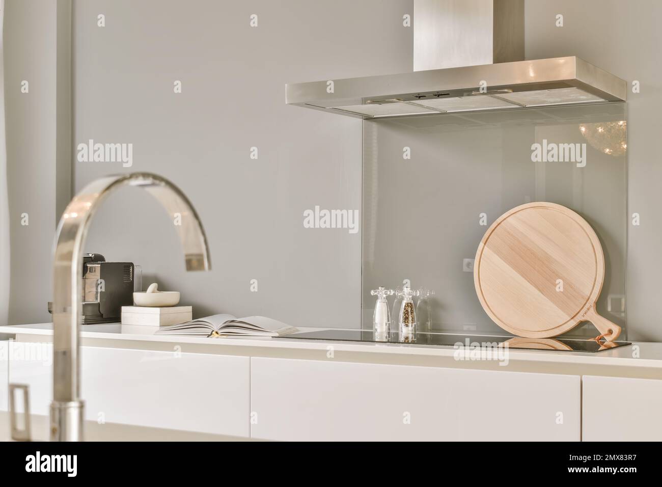 Interior of modern kitchen with range hood on wall placed above counter ...