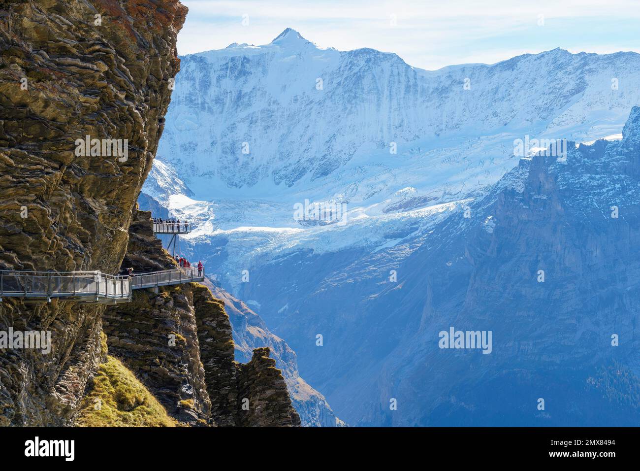 Tourists admire majestic snowy alpine mountains along a hair-raising ...