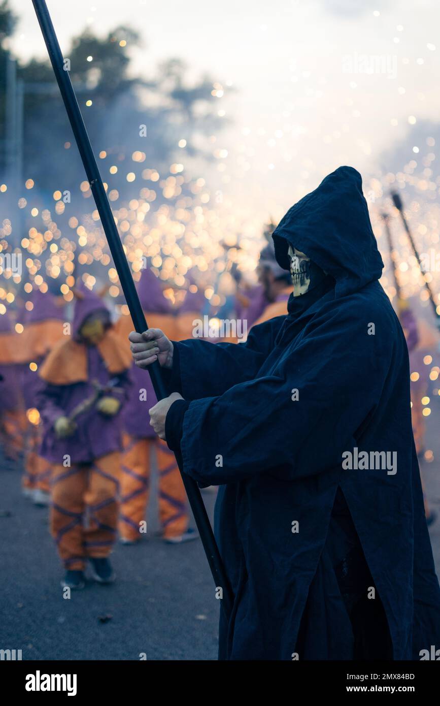 Side view of anonymous person in death costume with hood standing ...