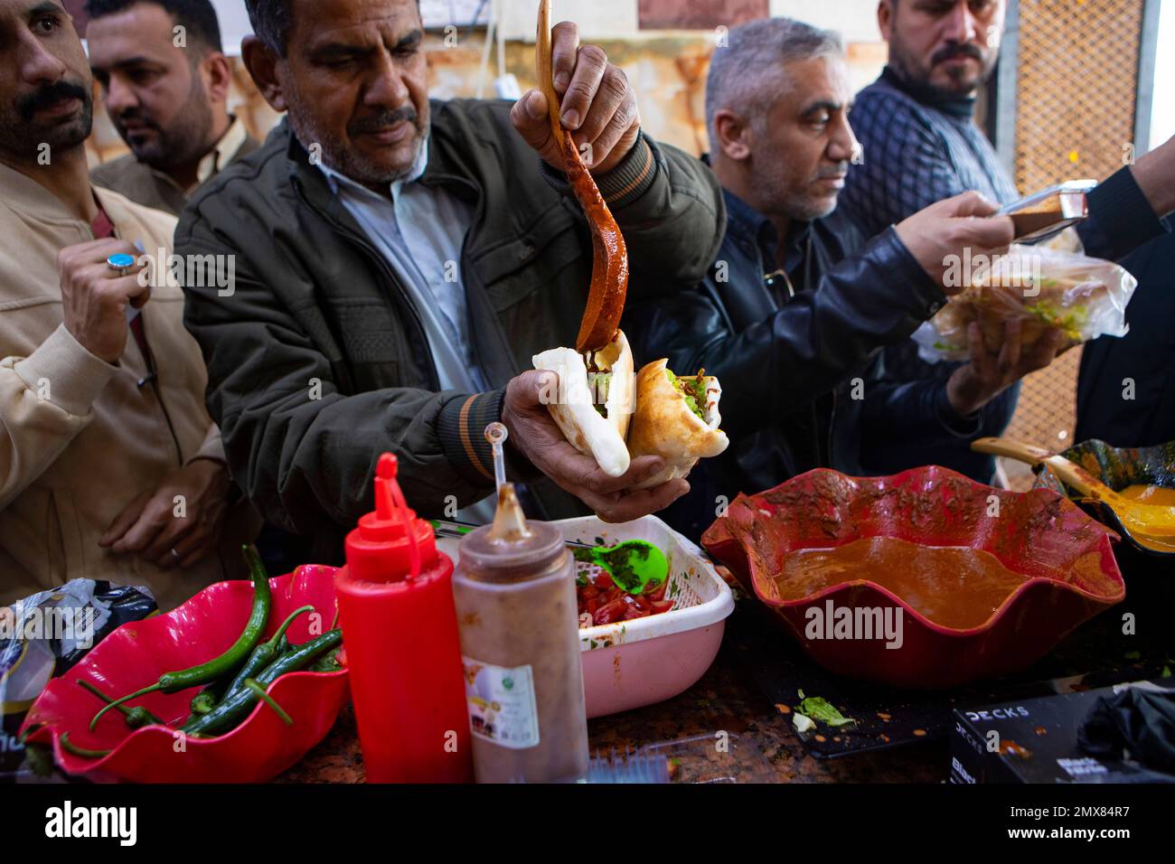 People wait to get sambusa sandwiches from famous restaurant in Basra ...