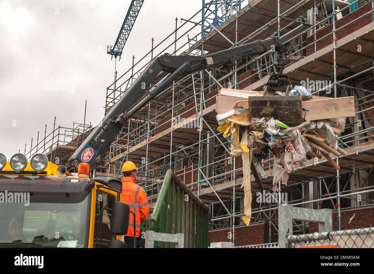 crane operator removes construction waste with a steel grab controlled ...