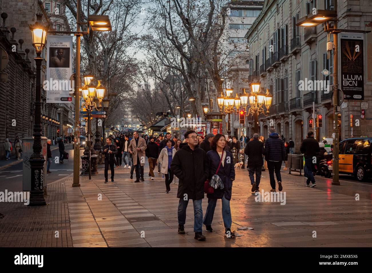 People walk down La Rambla avenue in Barcelona at dusk Stock Photo - Alamy