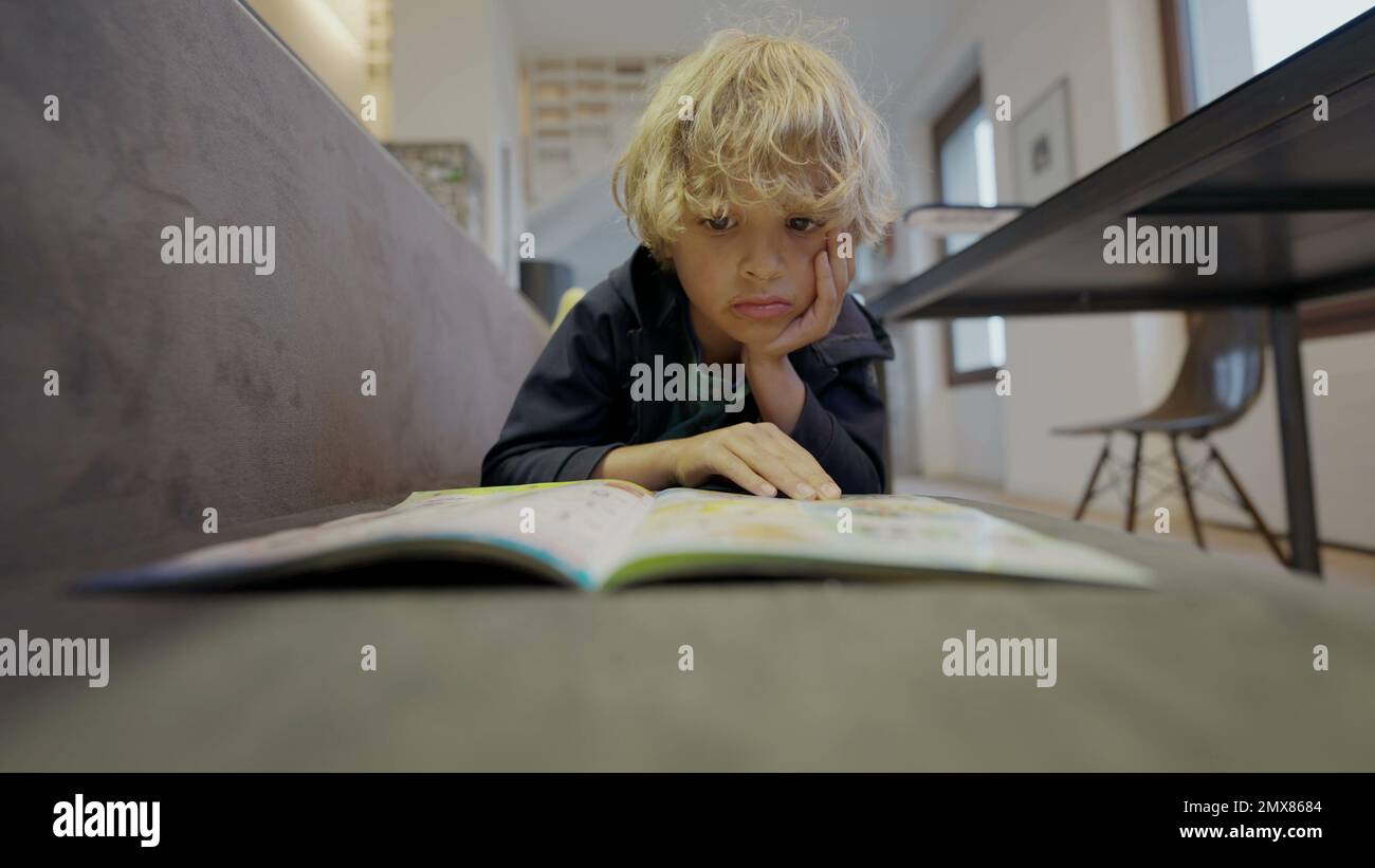 Child reading magazine at home indoors. One little boy hypnotized by ...