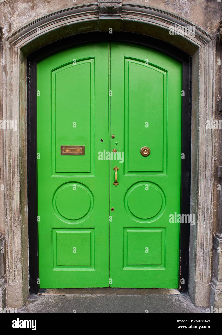 View of brightly colored traditional English green house door. Entrance ...