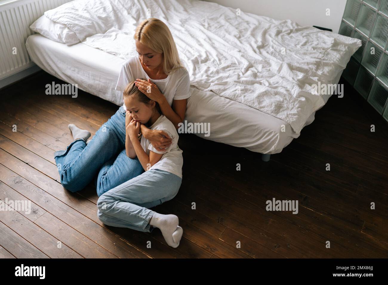High-angle view of loving caring mother comforting offended afraid little child daughter ...