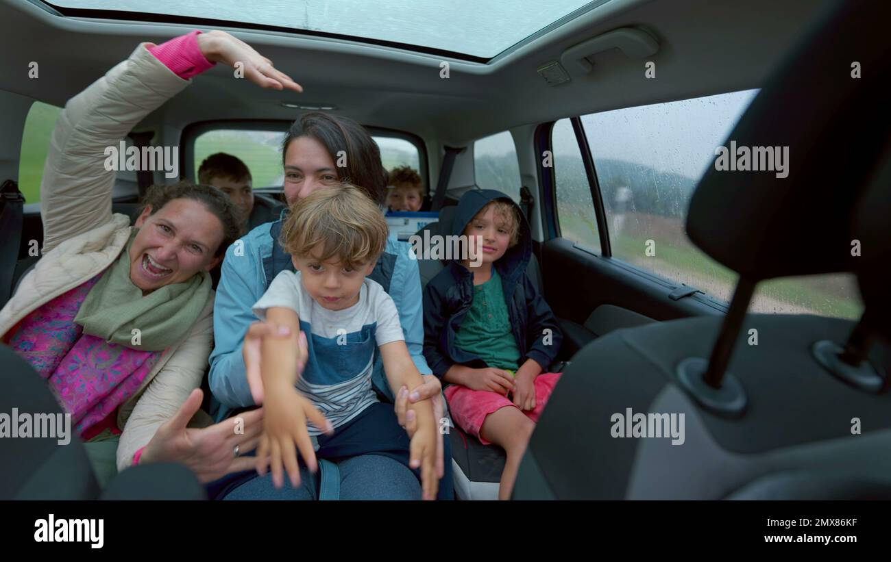 Happy people inside car backseat waving hands laughing and smiling ...