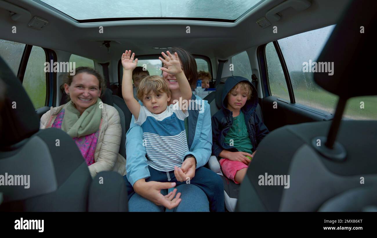 Happy people inside car backseat waving hands laughing and smiling ...