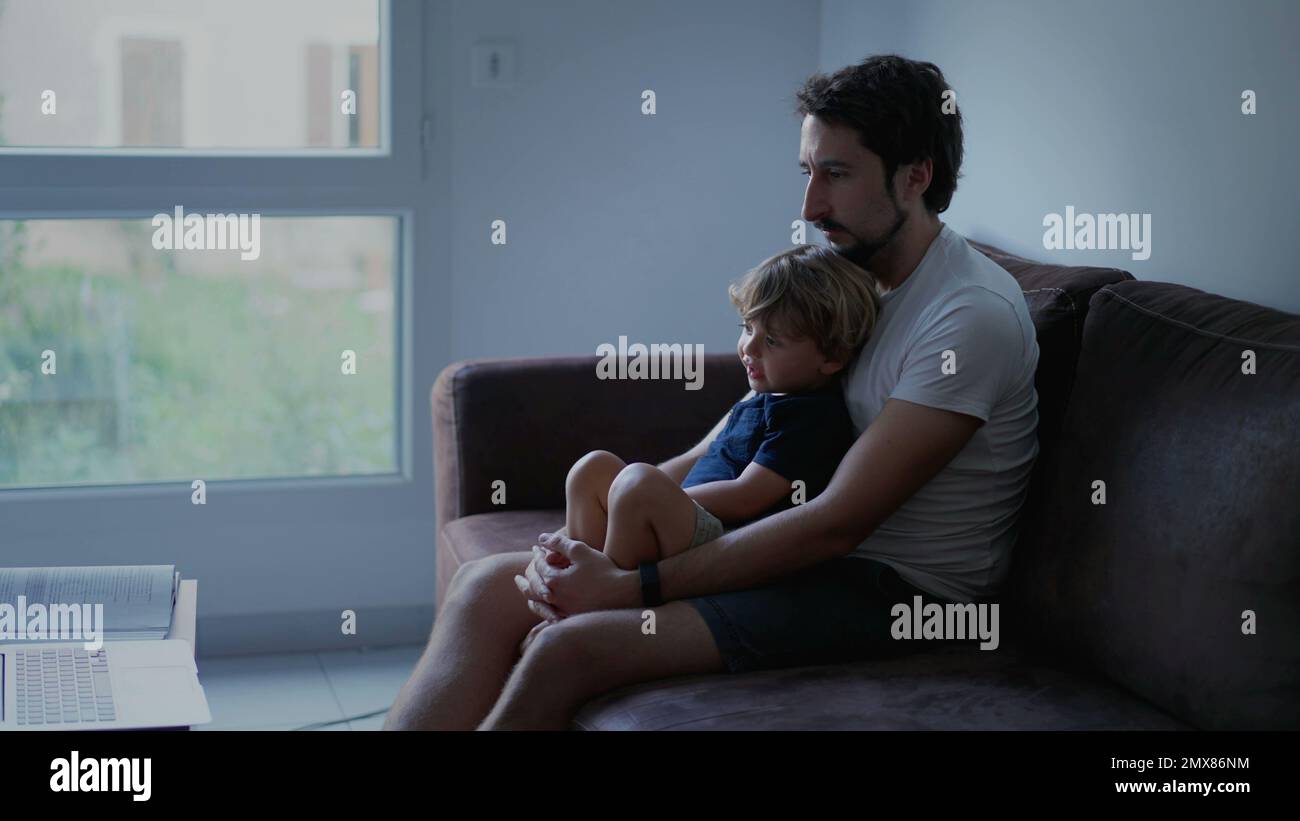 Father and son hanging out together in home couch. Candid child on dad ...