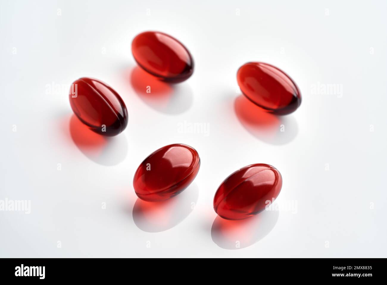 Five krill oil globules on a white background Stock Photo - Alamy