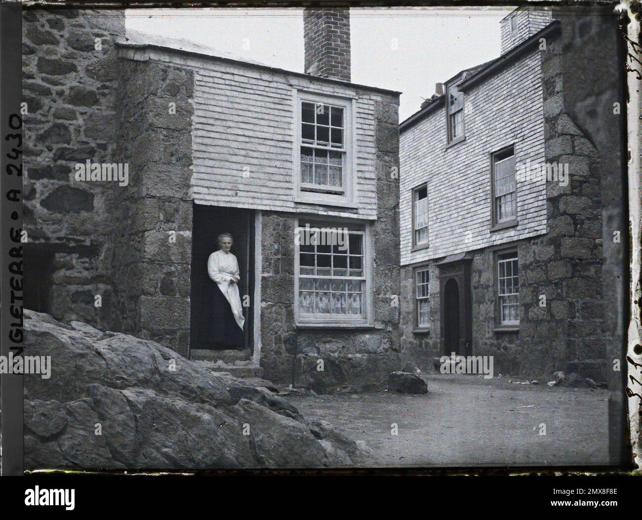 St Ives, Cornwall, England woman standing on the threshold of her house ...