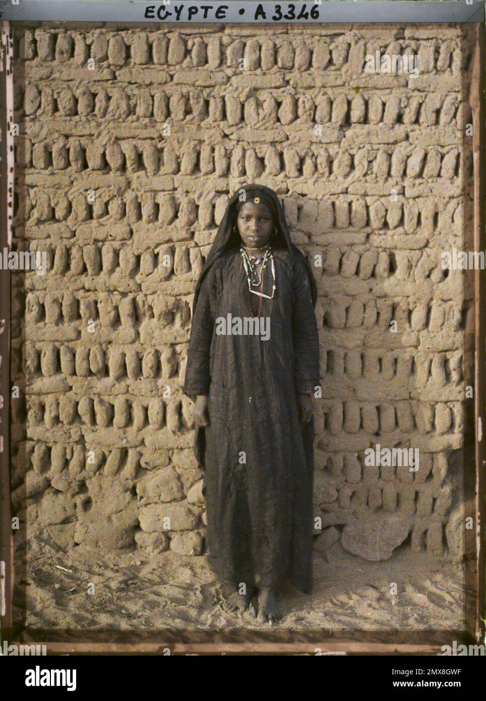 ASSOUAN, Egypt, Africa young Berber girl posing in front of a adobe ...