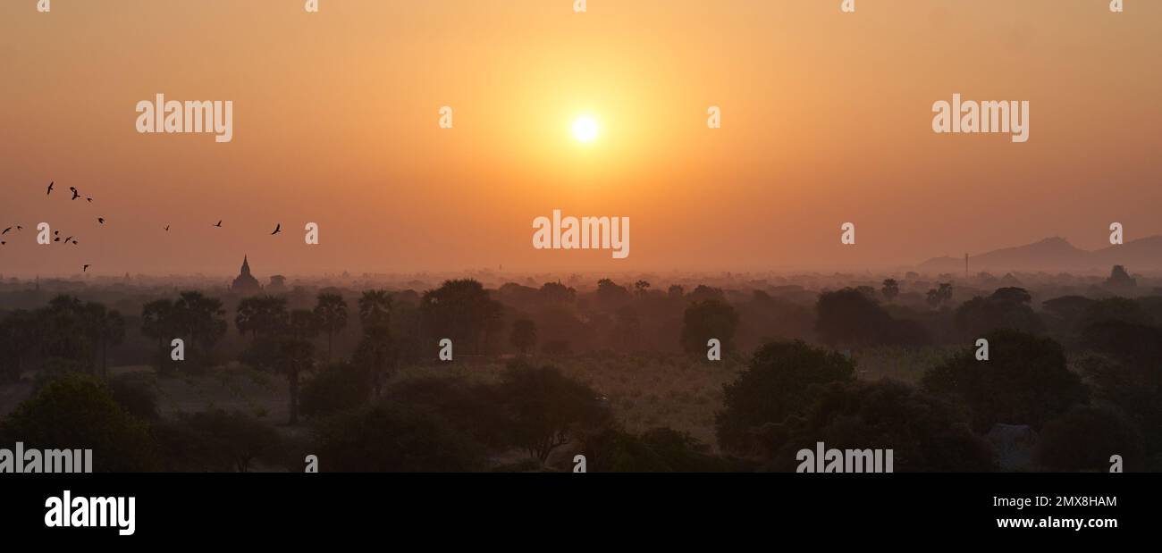 Sunrise in Bagan, Myanmar (Burma) with birds flying over ancient ...